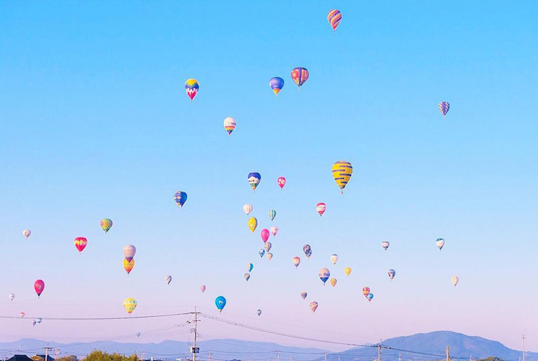 The fairy-tale like scene of colorful balloons soaring up into the sky ...
