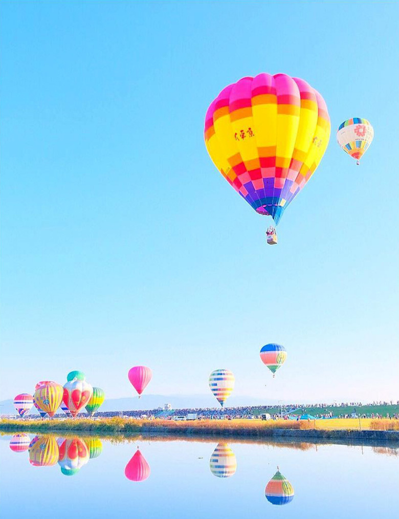 The fairy-tale like scene of colorful balloons soaring up into the sky ...