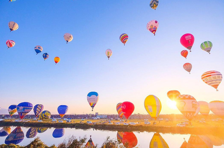 The fairy-tale like scene of colorful balloons soaring up into the sky ...