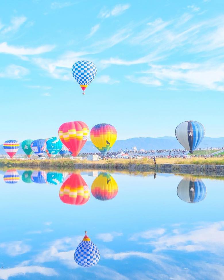 The fairy-tale like scene of colorful balloons soaring up into the sky ...