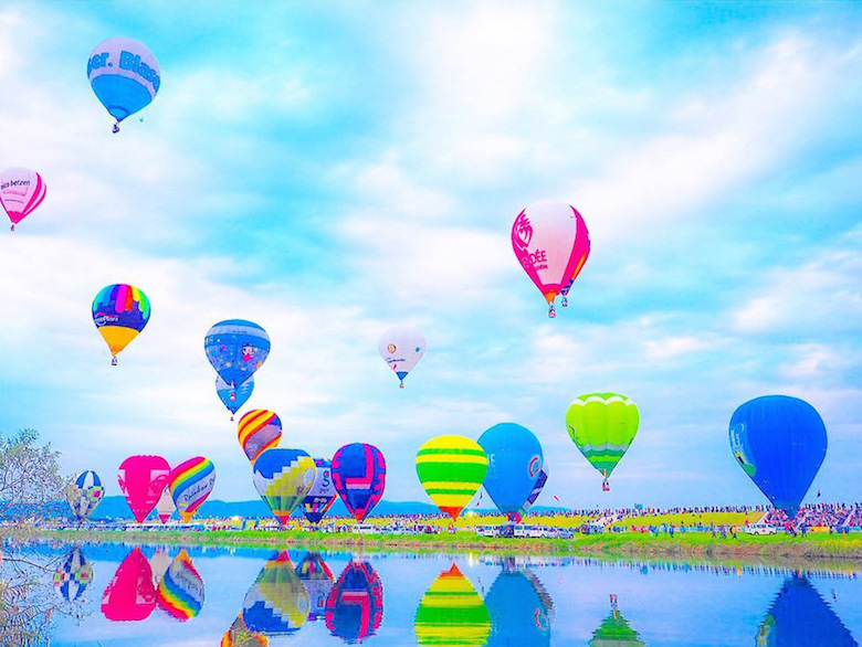 The fairy-tale like scene of colorful balloons soaring up into the sky ...